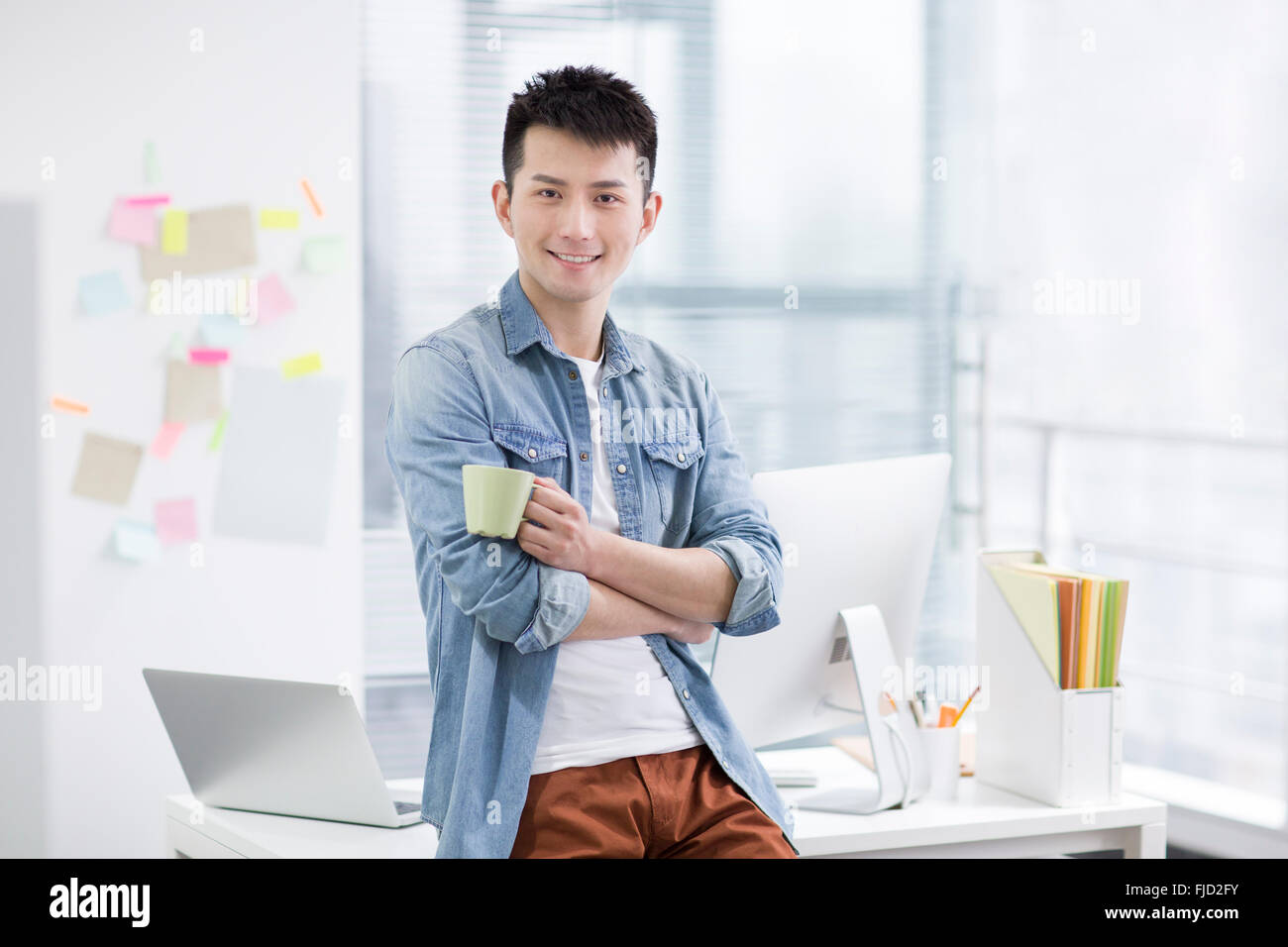 Portrait of young Chinese man in office Stock Photo - Alamy