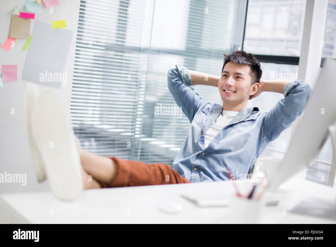 Young Chinese man thinking in office Stock Photo - Alamy