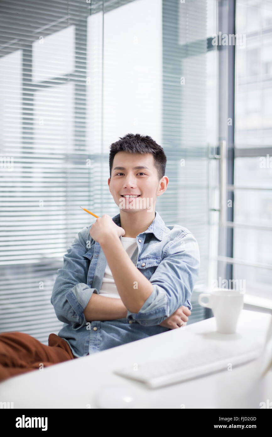 Portrait of young Chinese man in office Stock Photo - Alamy