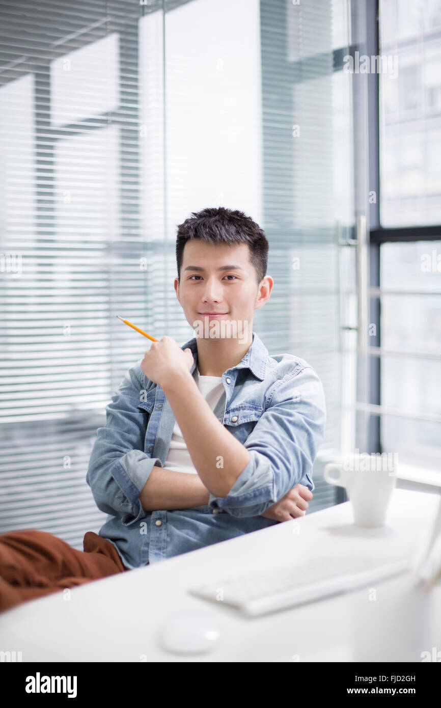 Portrait of young Chinese man in office Stock Photo - Alamy