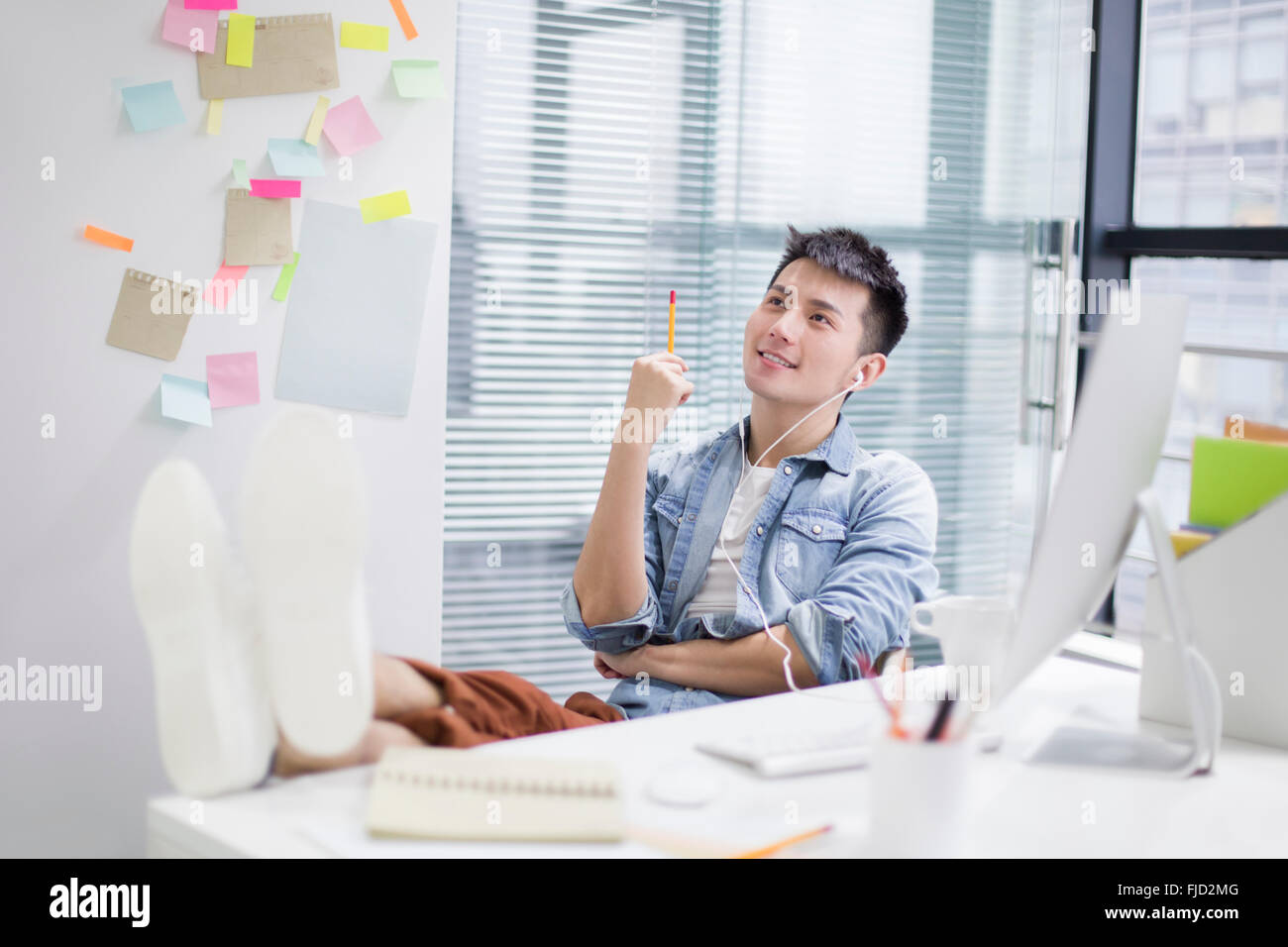Young Chinese man thinking in office Stock Photo - Alamy