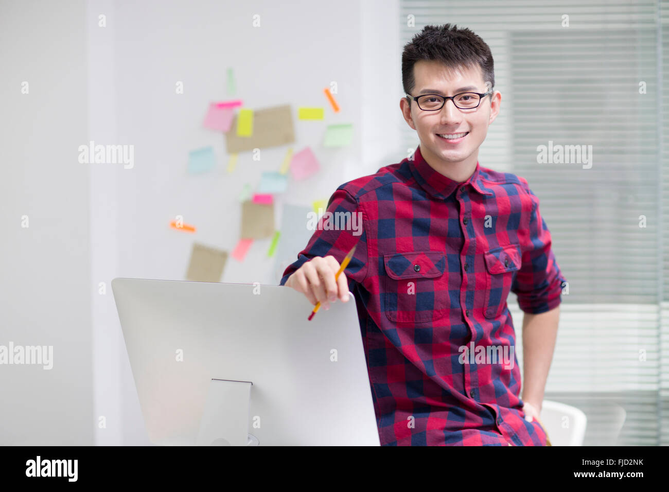 Portrait of young Chinese man in office Stock Photo - Alamy
