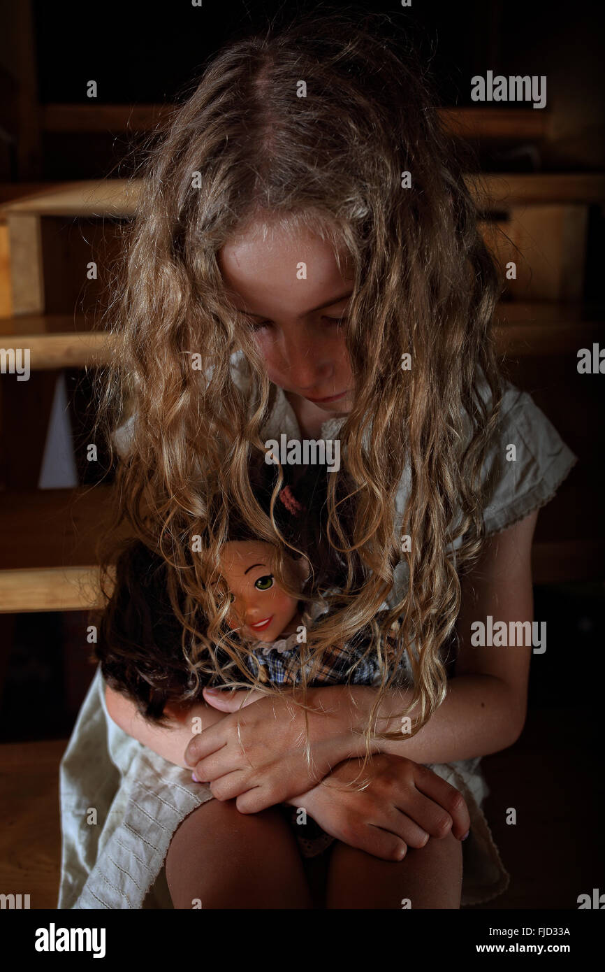 Sad and scared girl with a doll Stock Photo - Alamy