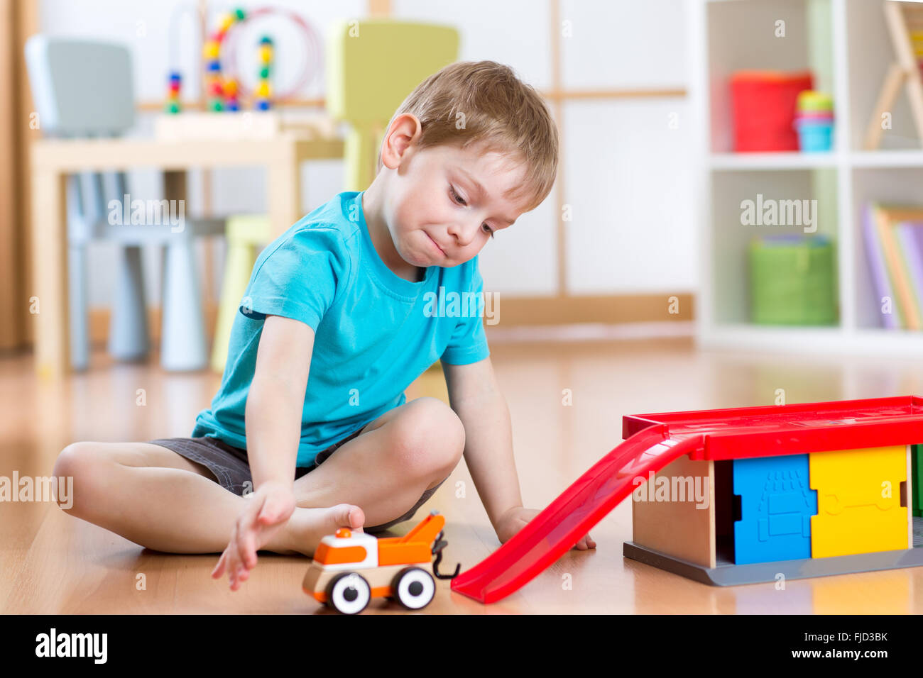 Little child playing with a toy car in nursery Stock Photo - Alamy