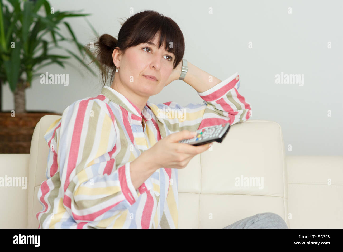 Woman watching television changing channels hi-res stock photography ...