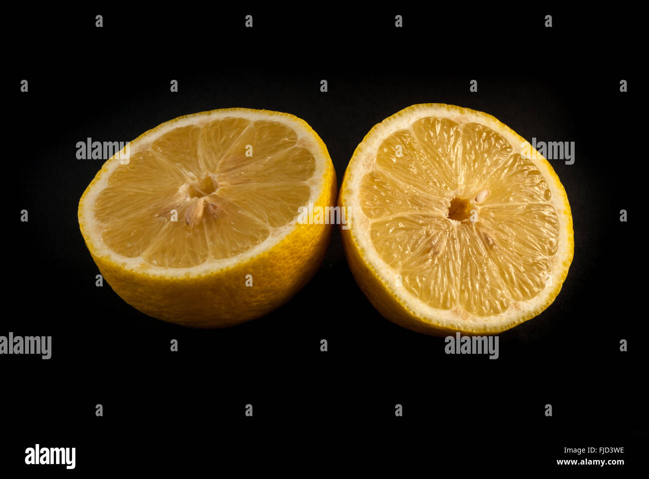 Fresh yellow lemon cut in half isolated on black background Stock Photo ...