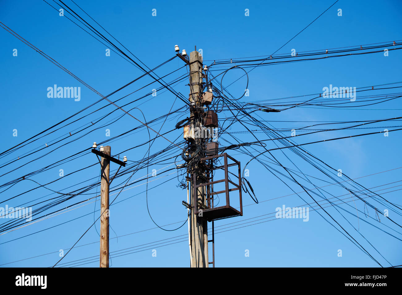 Two electric poles with unorganized cables Stock Photo - Alamy