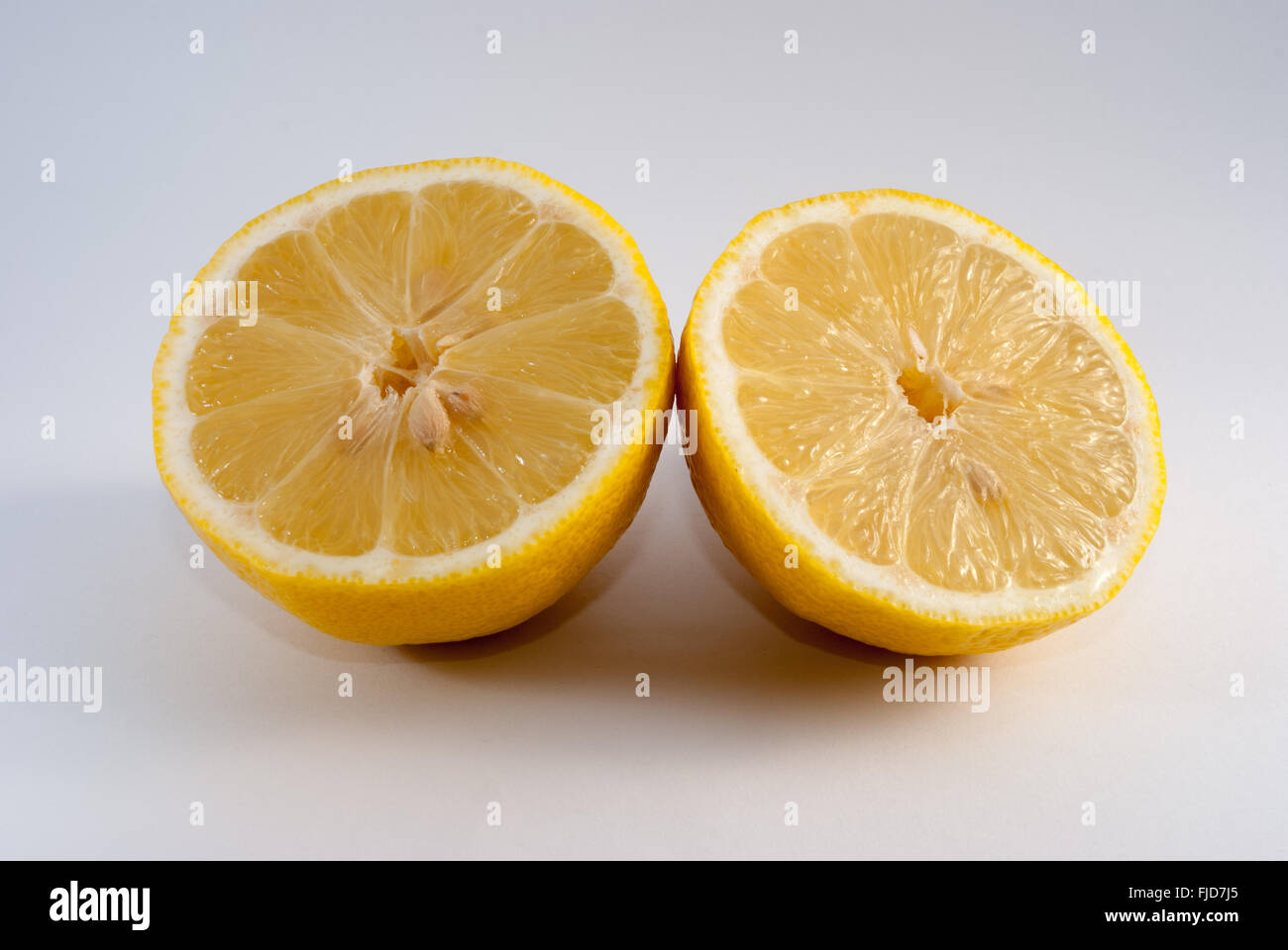 Fresh yellow lemon cut in half on white background Stock Photo - Alamy