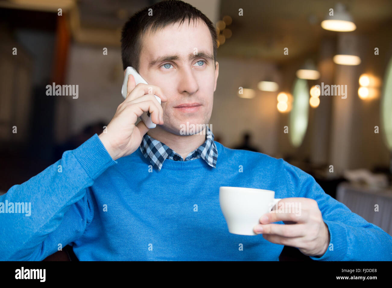 Portrait of casual relaxed smiling young business man sitting indoors ... Portrait of casual relaxed smiling young business man sitting indoors ...