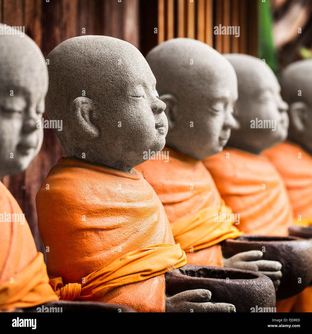 Monk statue holding bowl Stock Photo - Alamy