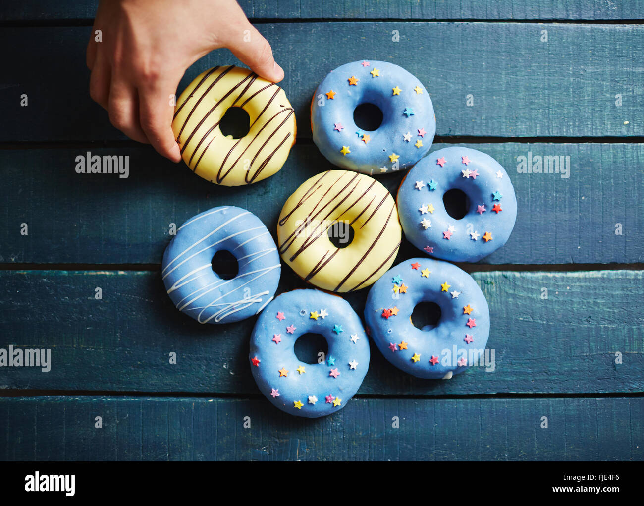 Hand grabbing donut hi-res stock photography and images - Alamy