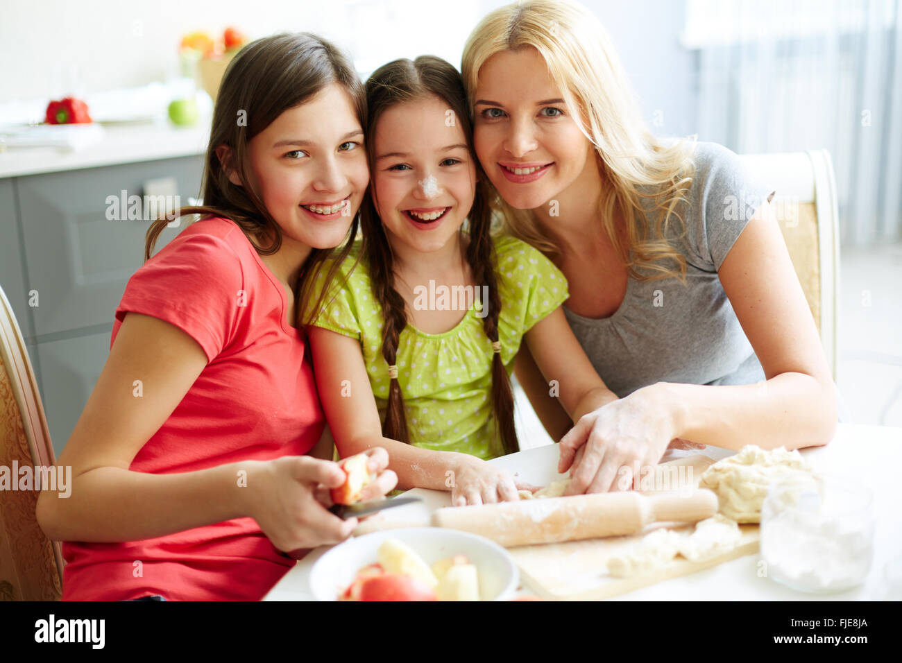 Happy family of three cooking together in the kitchen Stock Photo - Alamy