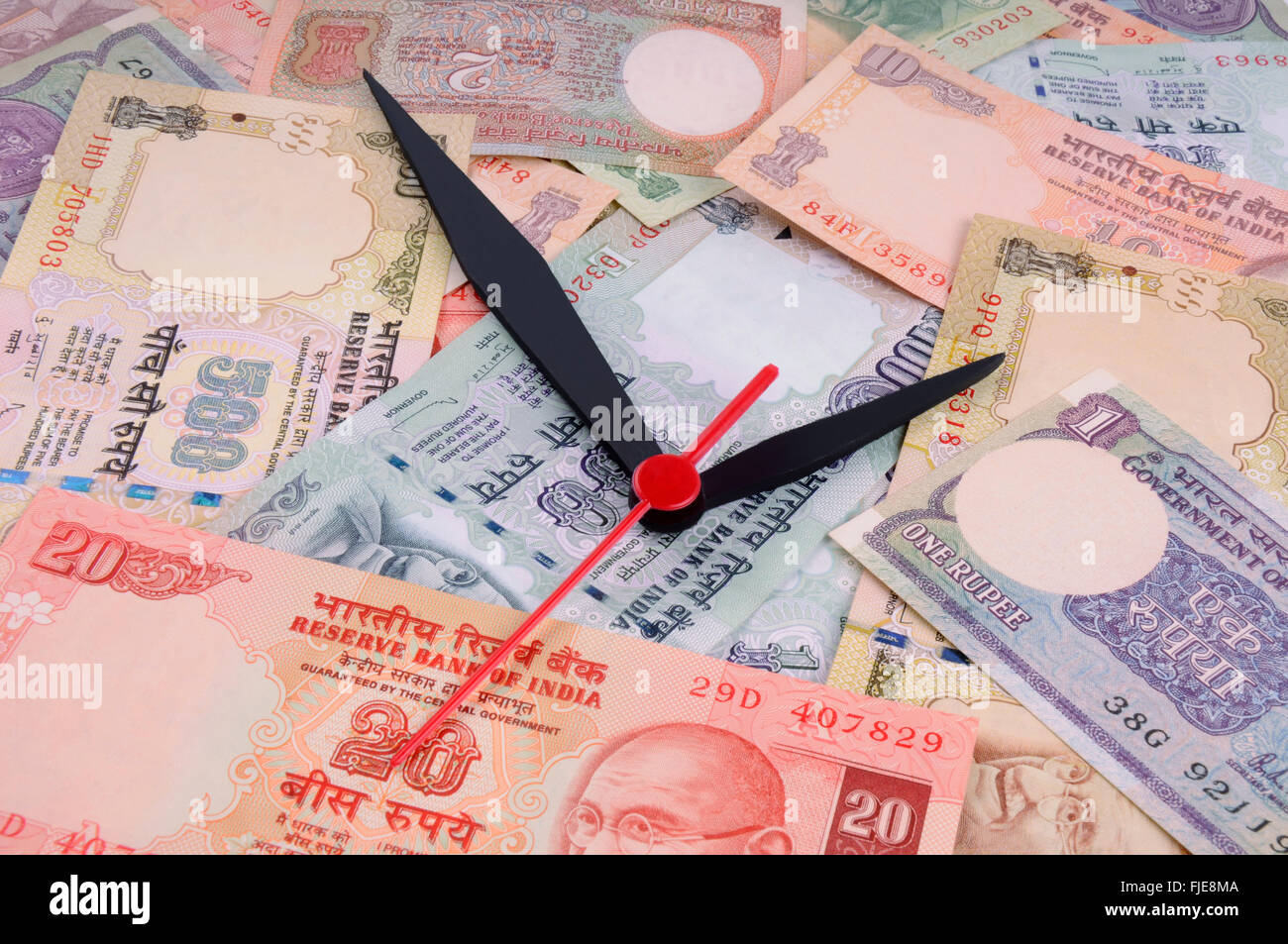 "Time is money" concept - clock and Indian rupee Stock Photo - Alamy