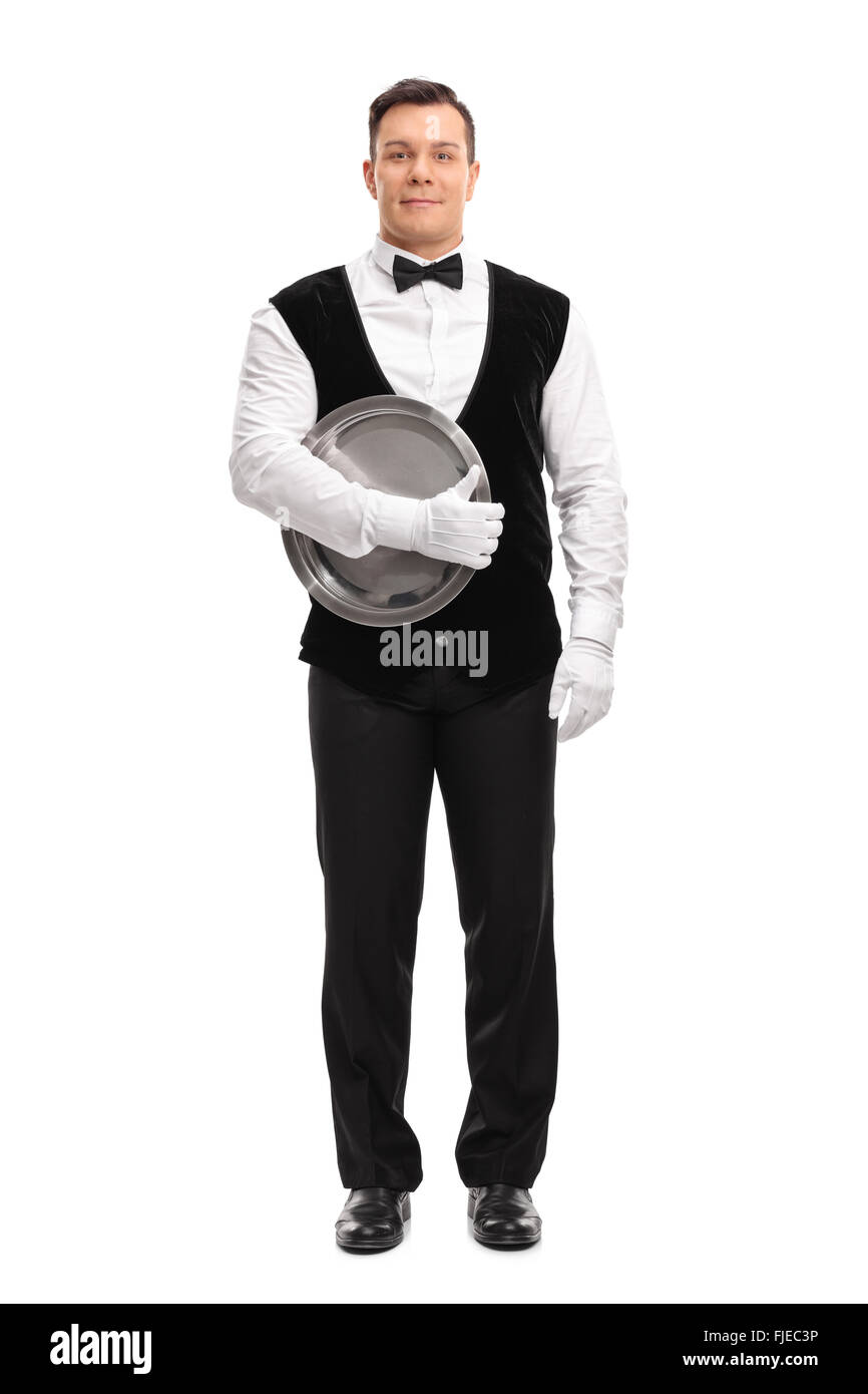 Full length portrait of a young male waiter holding a tray and looking ...