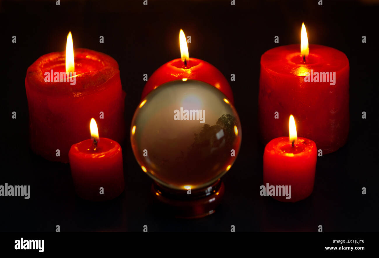 Crystal ball with five red candles burning Stock Photo - Alamy