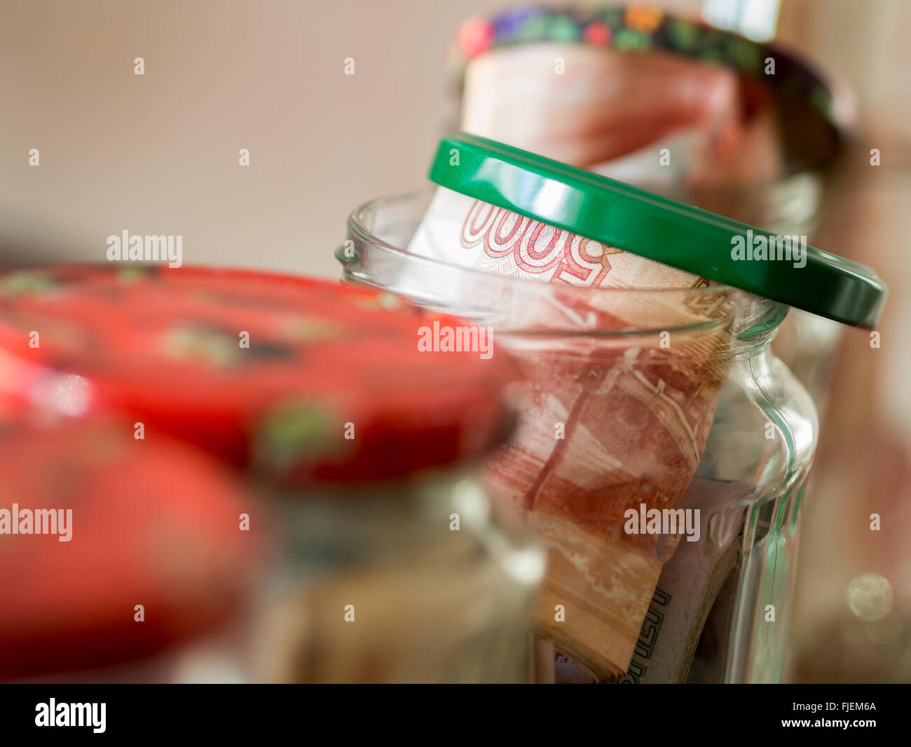 Jars of cash. Glass jars with banknotes Stock Photo - Alamy
