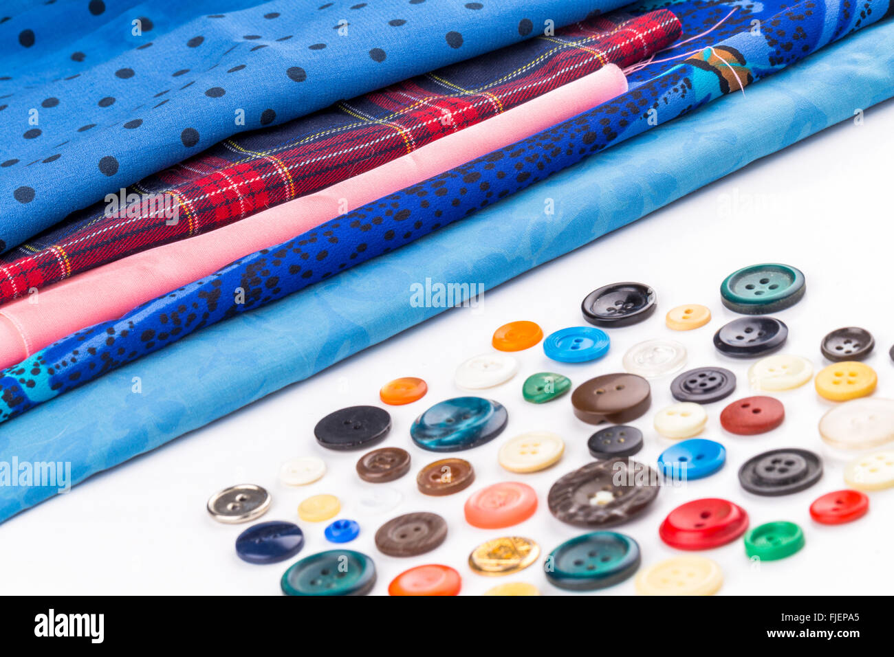 Colored buttons and cloth on white background Stock Photo - Alamy