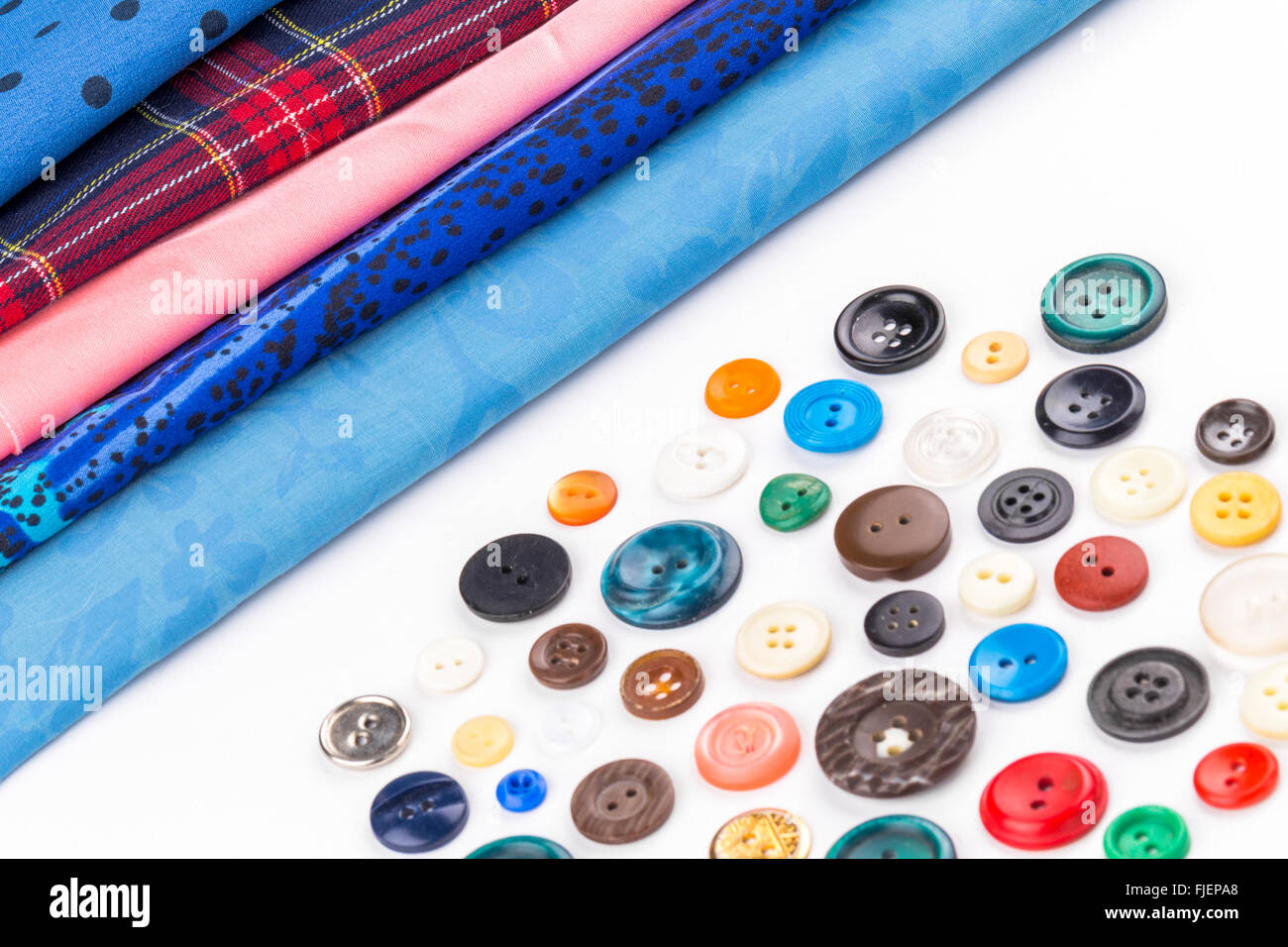 Colored buttons and cloth on white background Stock Photo - Alamy