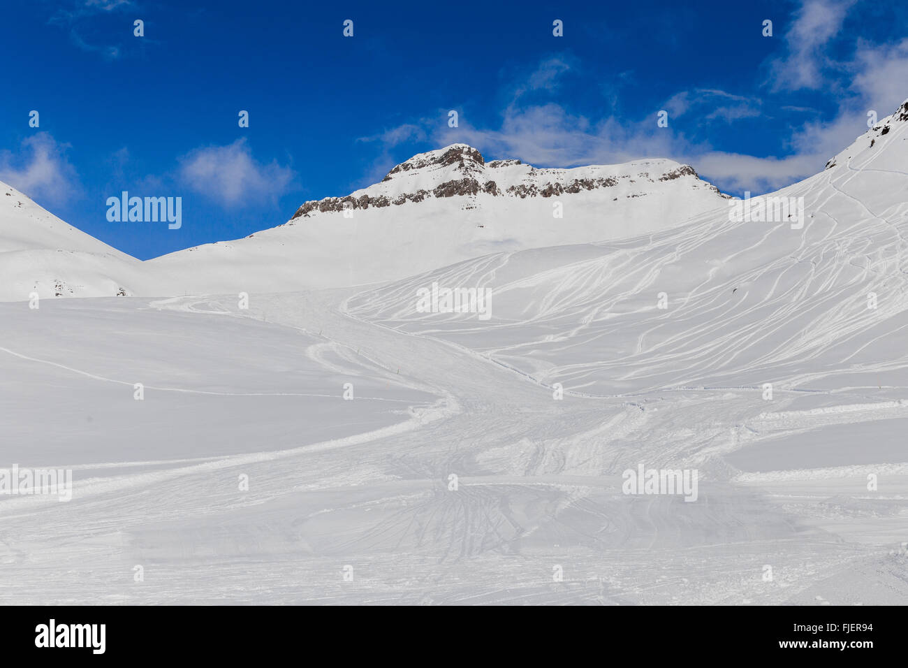 Snowy mountains with ski tracers Stock Photo - Alamy