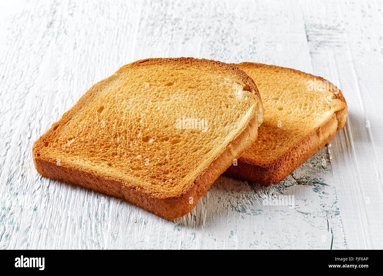 Pieces of sliced toast bread on white wooden table Stock Photo - Alamy