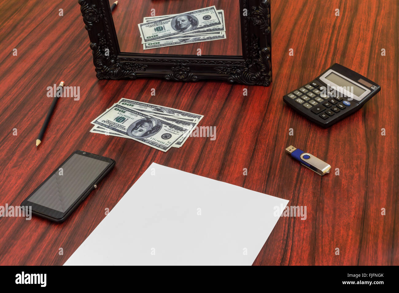 Money with reflection in the mirror laying on a table surrounded by ...