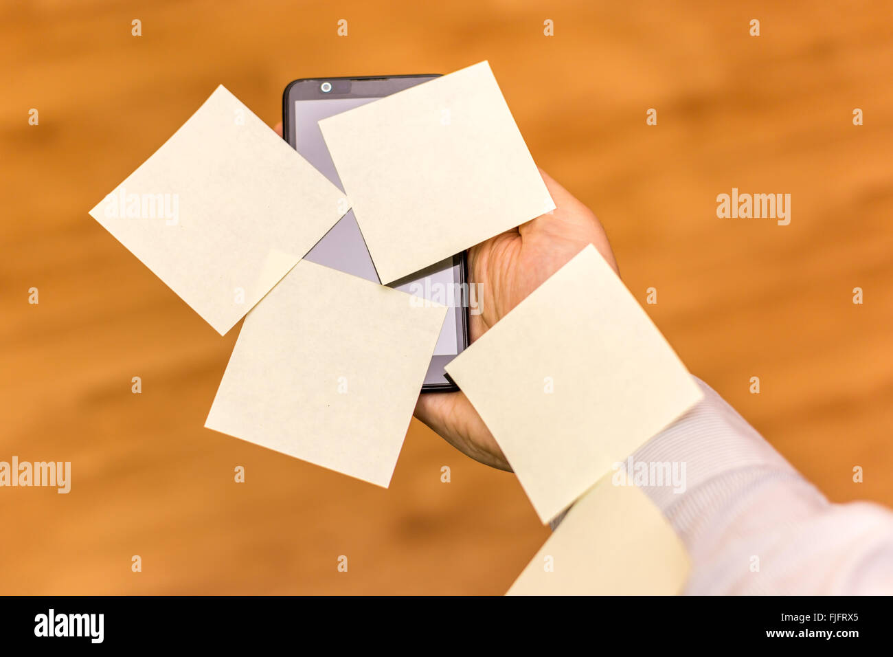 Human hand holdin a smarthpne covered with yellow sticky notes Stock ...