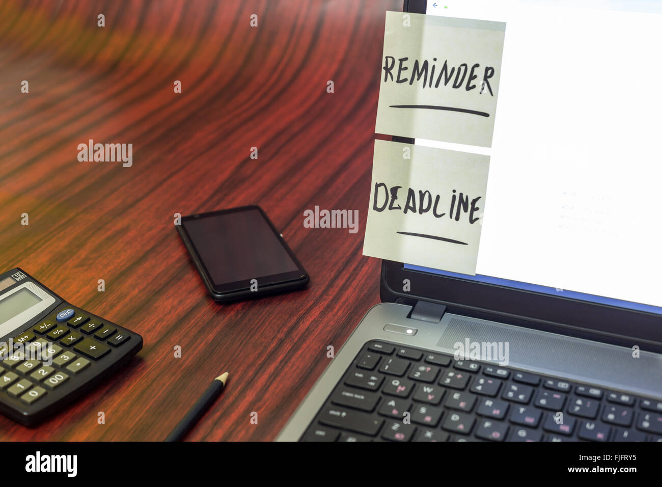 Two yellow notes with the words deadline and reminder sticked to a ...