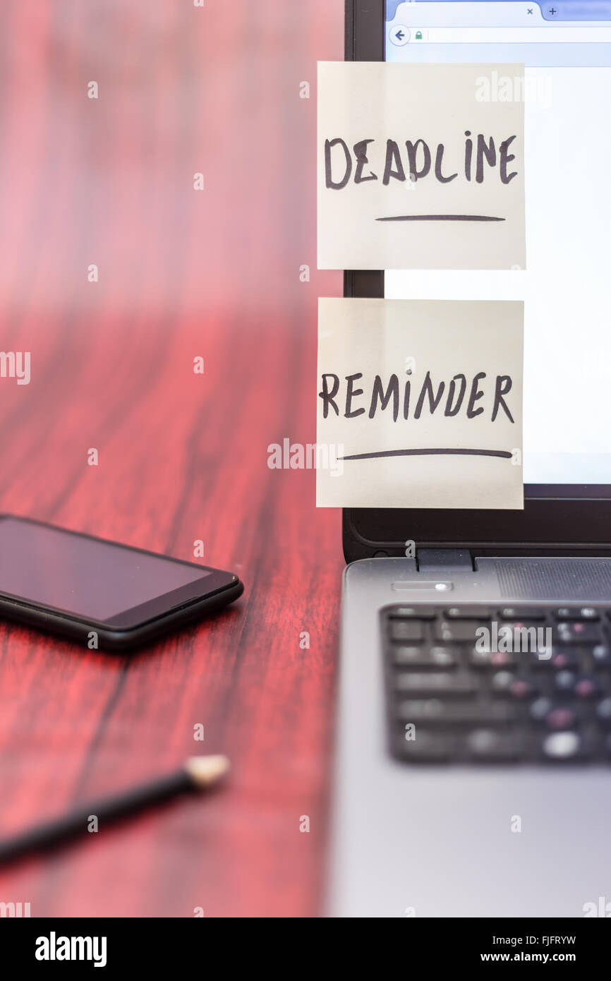 Two yellow notes with the words reminder and deadline sticked to a ...