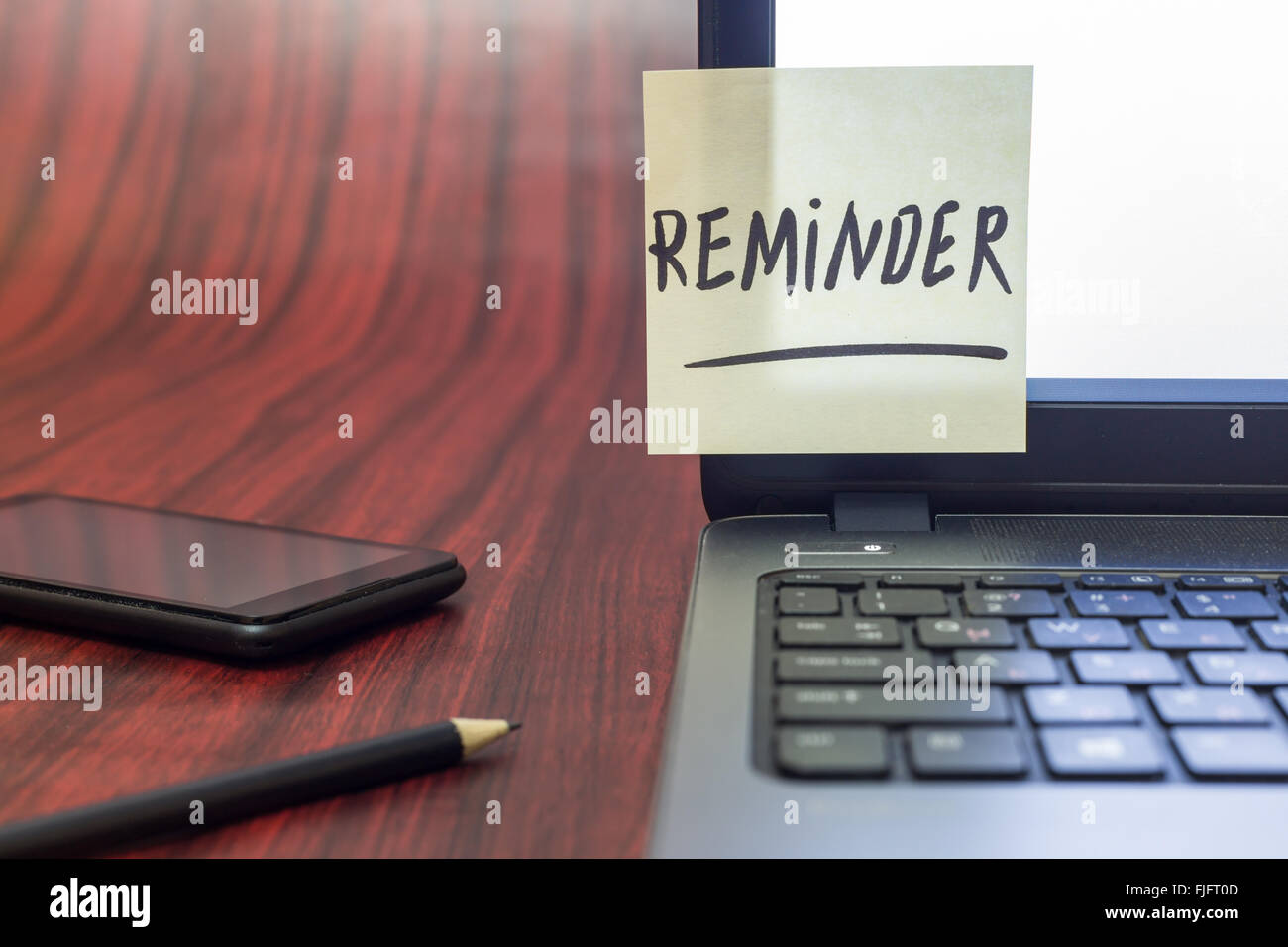 Yellow note with the word reminder taped on a laptop display Stock ...