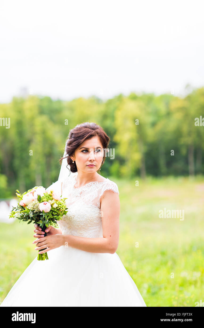 Young bride holding big wedding bouquet Stock Photo - Alamy