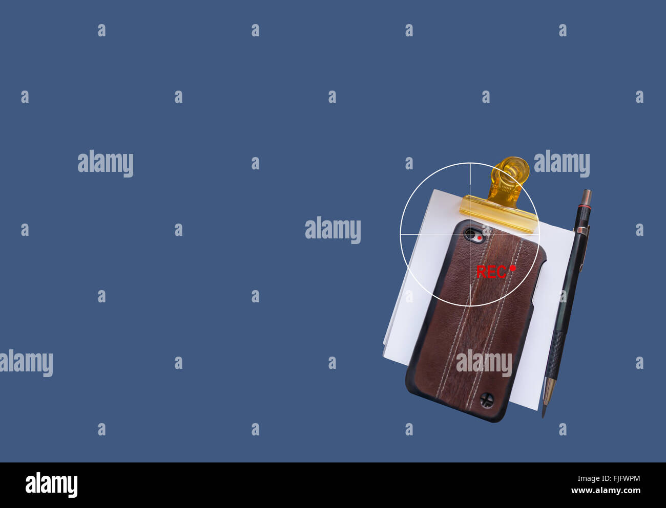 Secretly video streaming moblie phone with pencil on plain blue ...