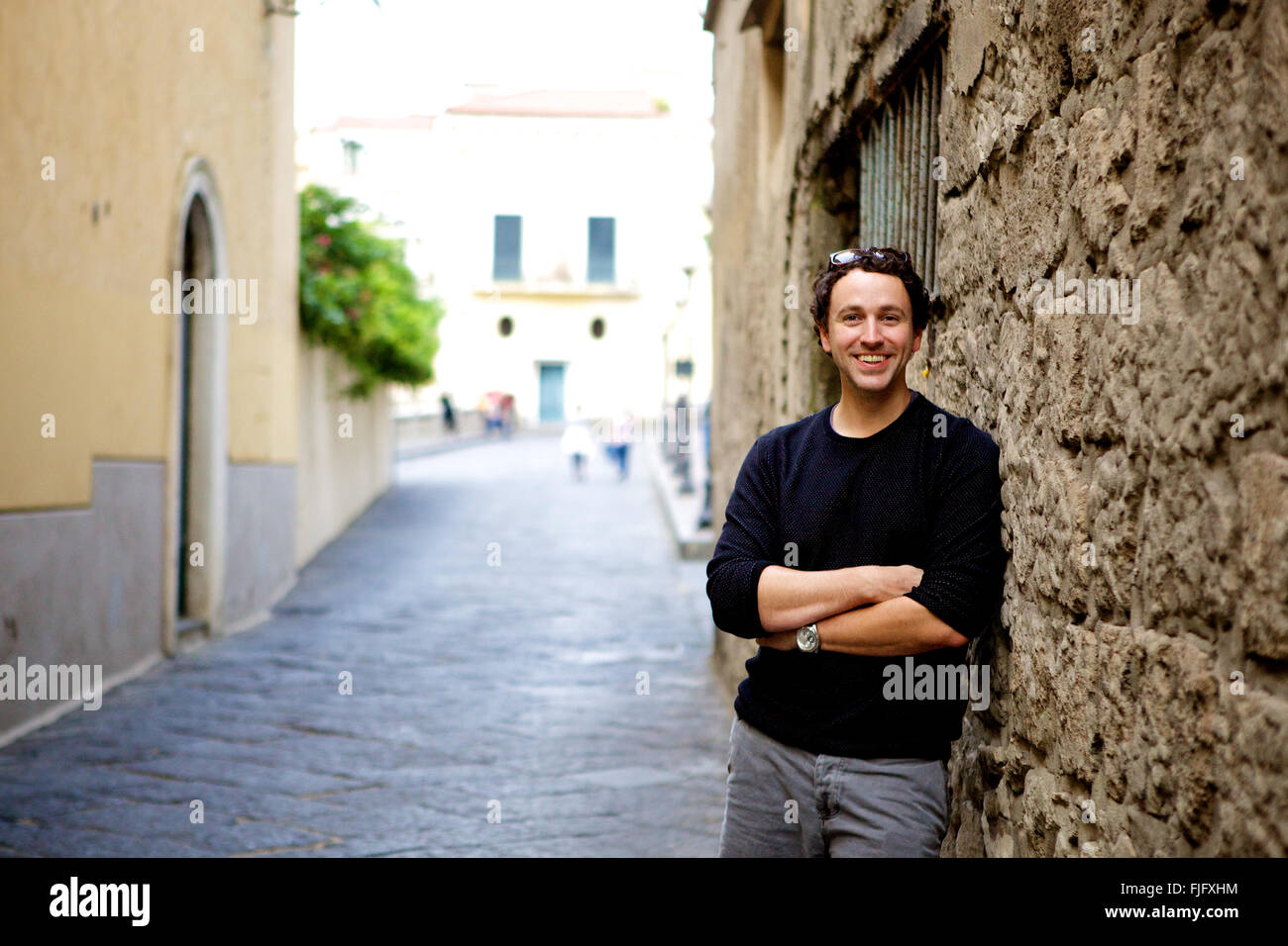 A young brunette dashing man standing in a traditional Sorrento street ...
