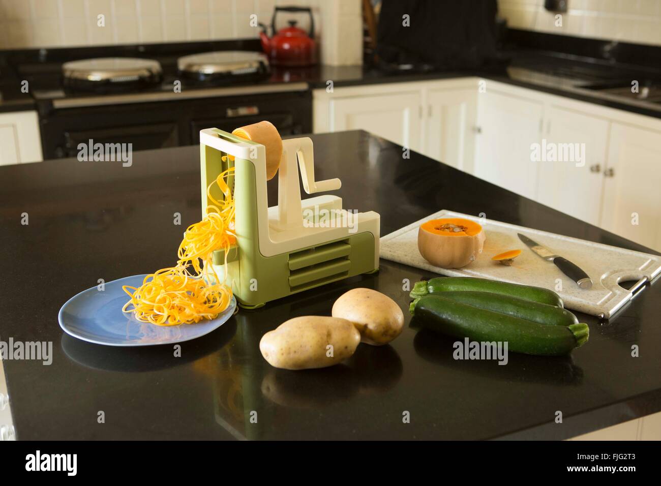 Making courgette noodles or "courgetti" in a family kitchen using a ...