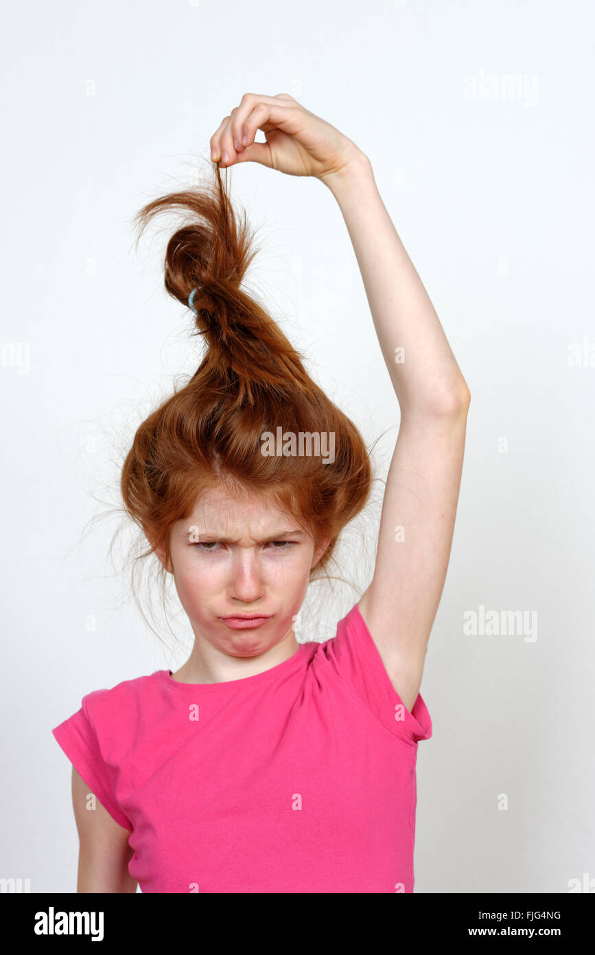 Girl with long red hair with grim face, pulling her hair, Bavaria ...