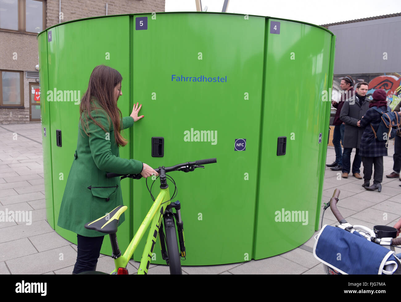 Berlin, Germany. 2nd Mar, 2016. A cyclist pushes her bicycle into a ...