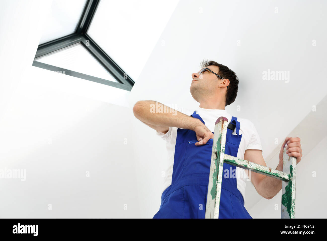 Fitter roof windows. Handyman, a man with a drill. Skylights ...