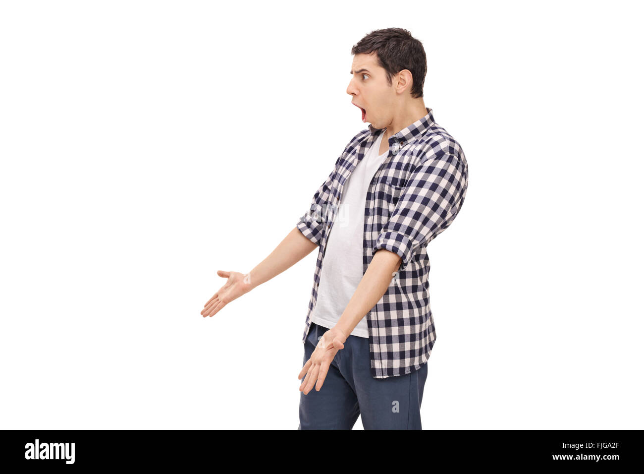 Studio shot of an angry young man arguing with someone isolated on ...