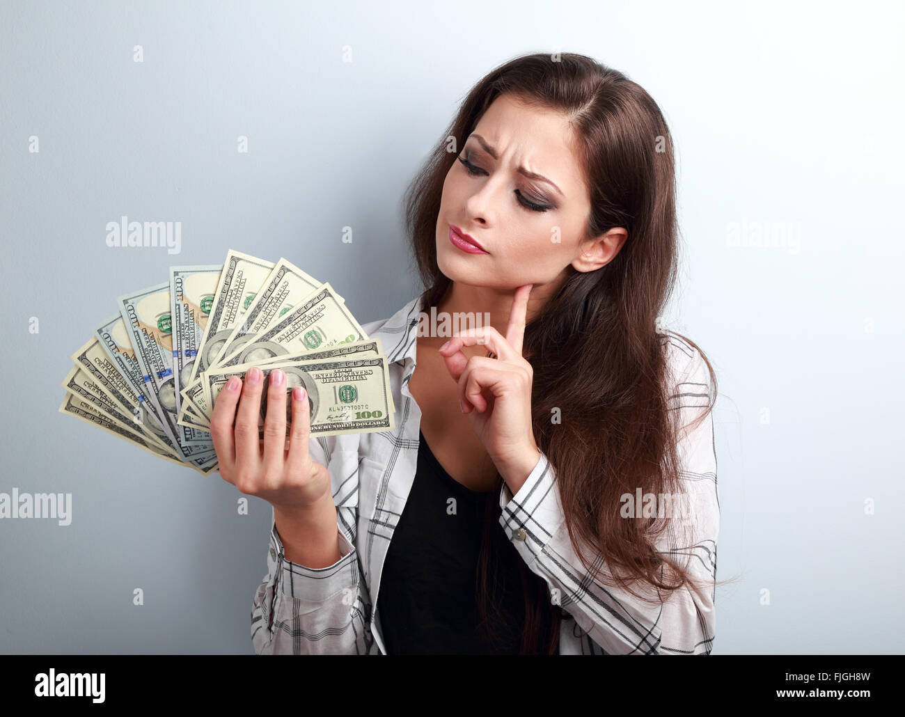 Serious concentrated thinking business lady thinking where invest money ...