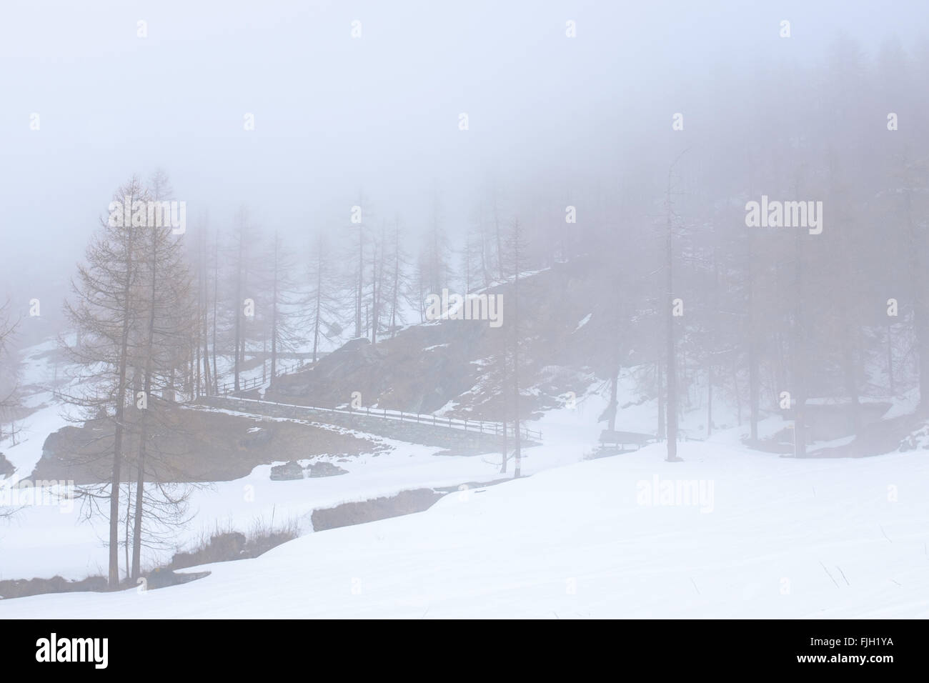 Fog and cloud covering a snowy mountain path Stock Photo - Alamy