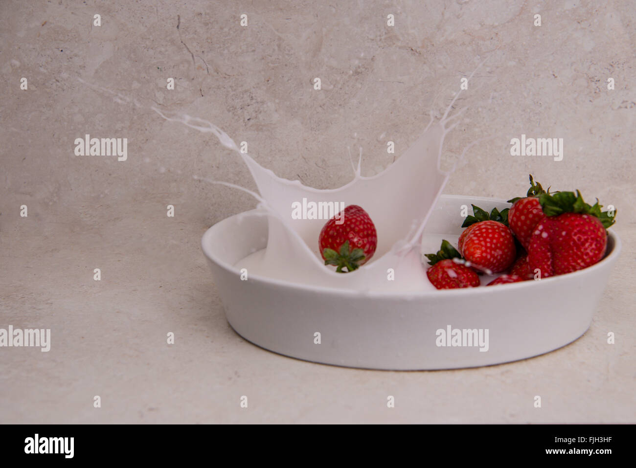 Strawberry splash in cream hi-res stock photography and images - Alamy