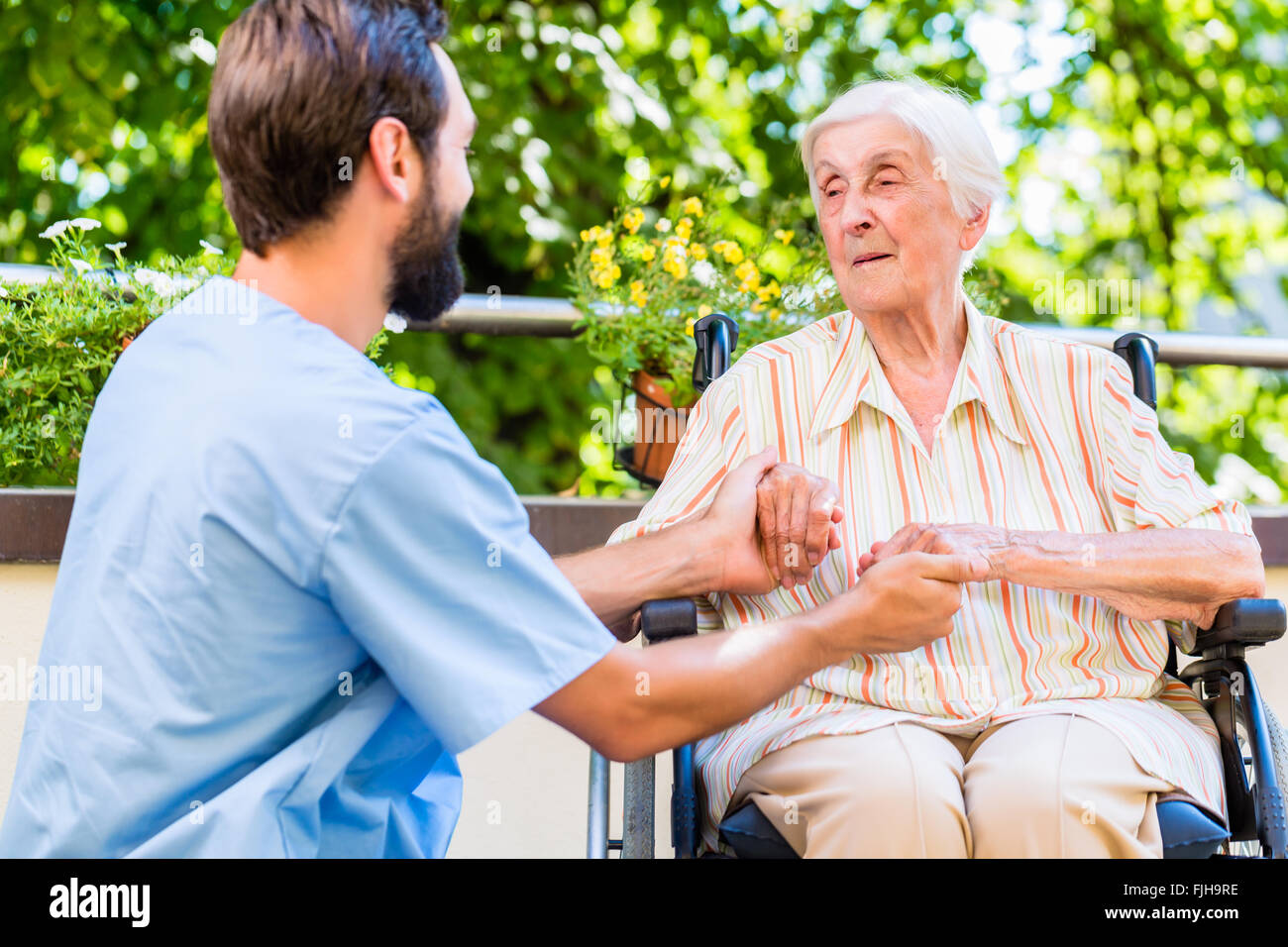 Geriatric nurse holding hand of old woman in rest home Stock Photo - Alamy