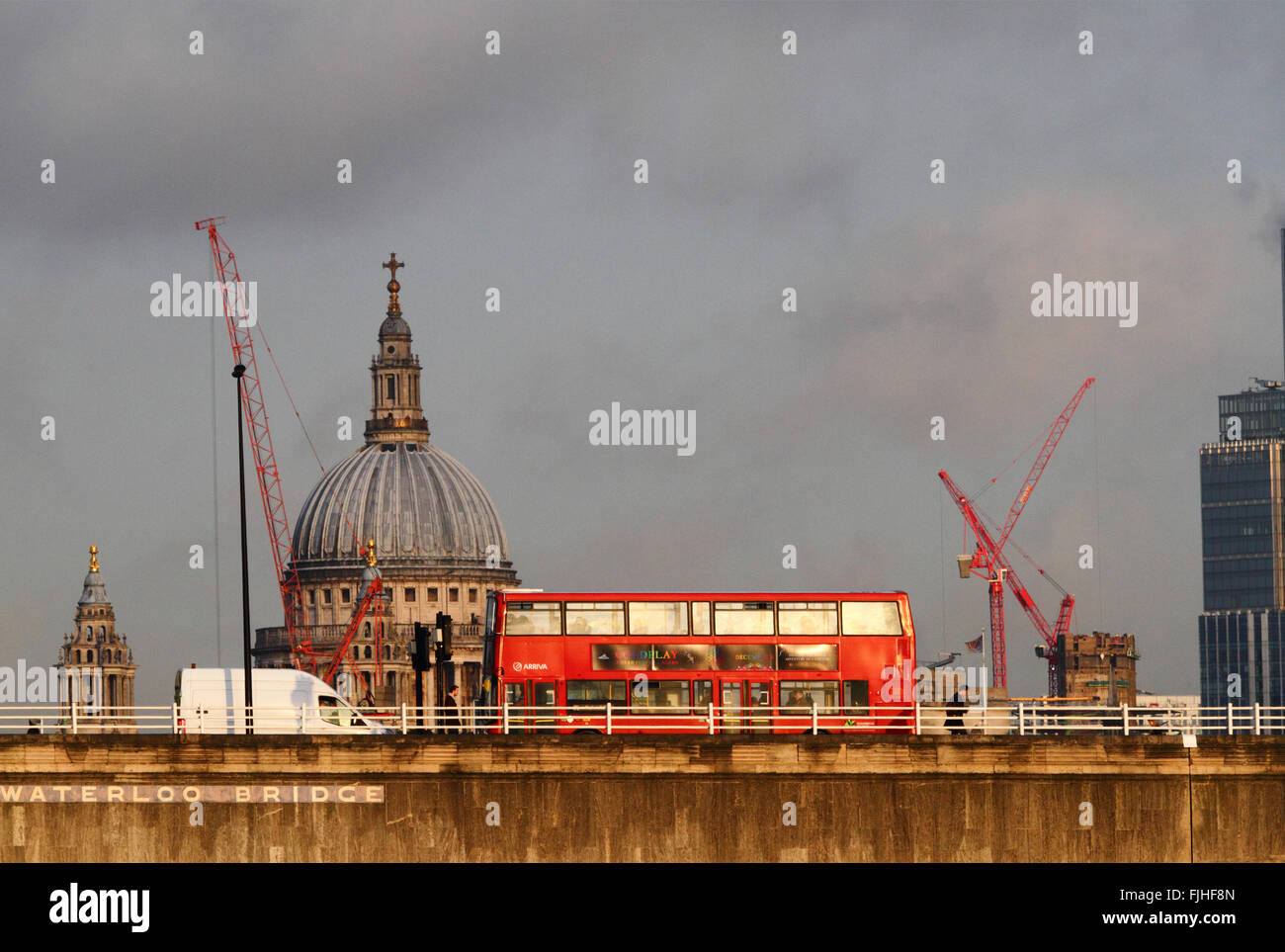 Red double deck bus crossing Waterloo Bridge, St Paul's Cathedral dome ...