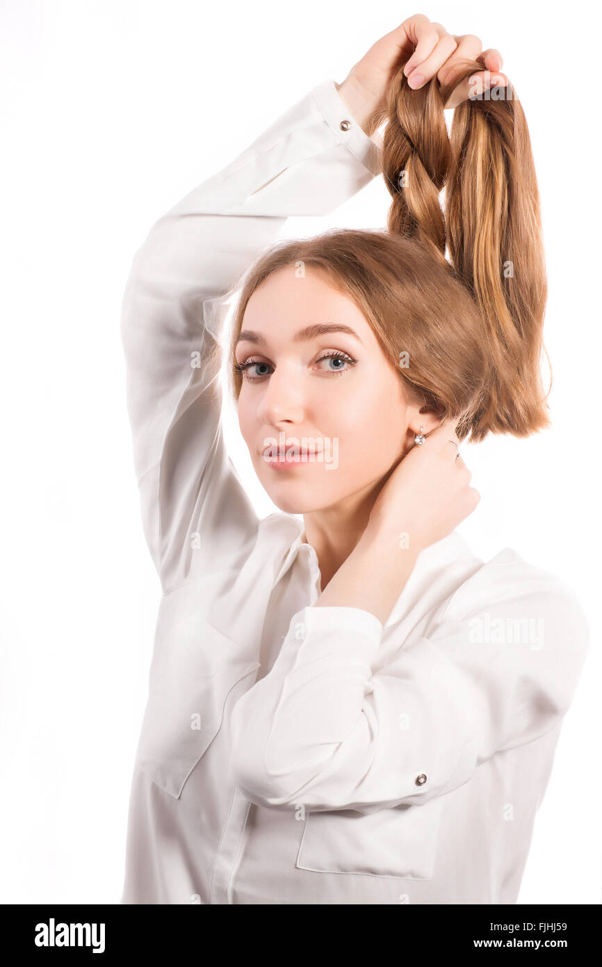 Young woman with clean natural skin holding her raised beautiful long ...