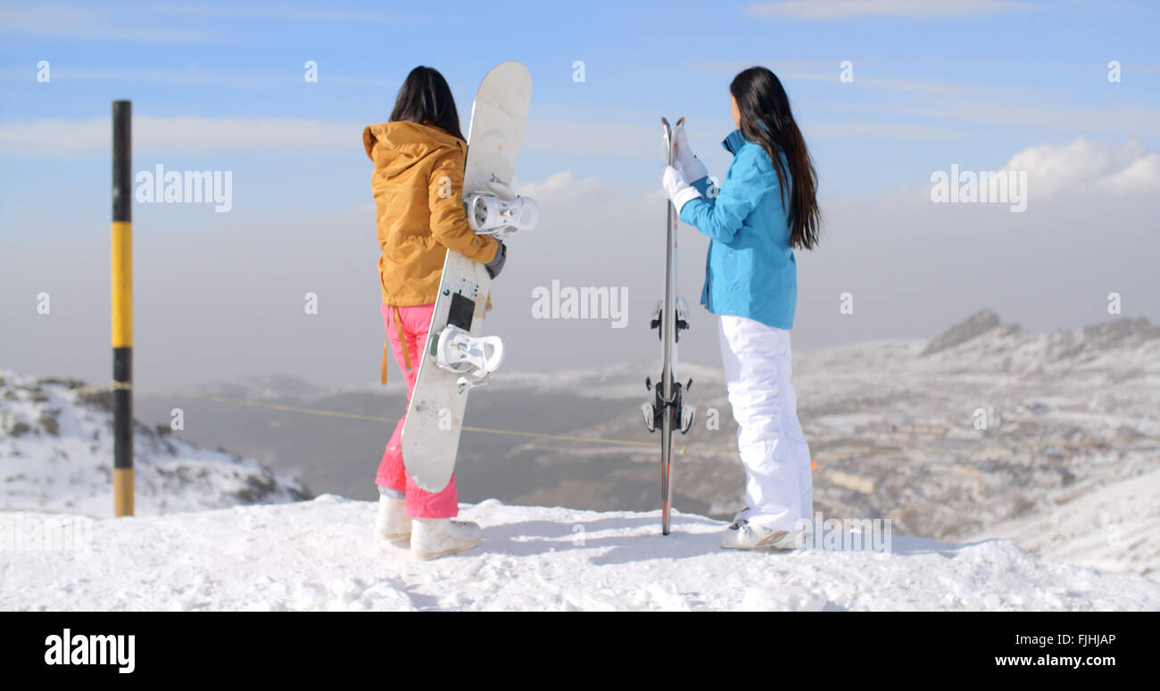 Two women snowboarders enjoying the winter view Stock Photo - Alamy