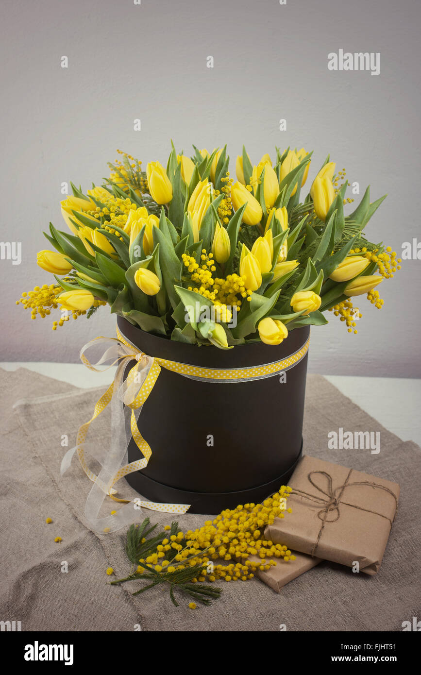 Bright spring bouquet of tulips and mimosa flowers. Mother's Day or ...
