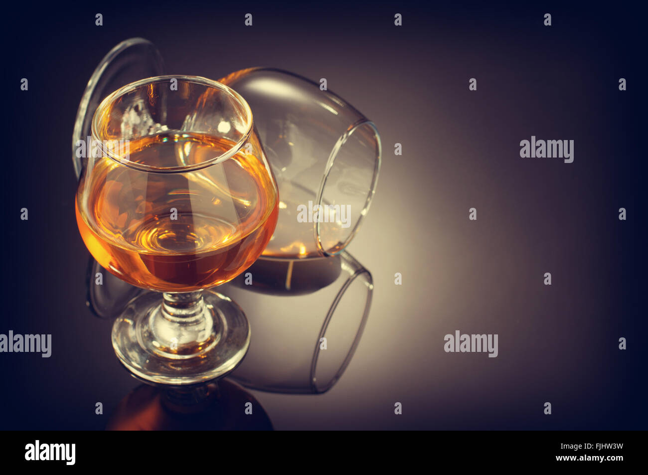 cognac and glass on black background Stock Photo - Alamy