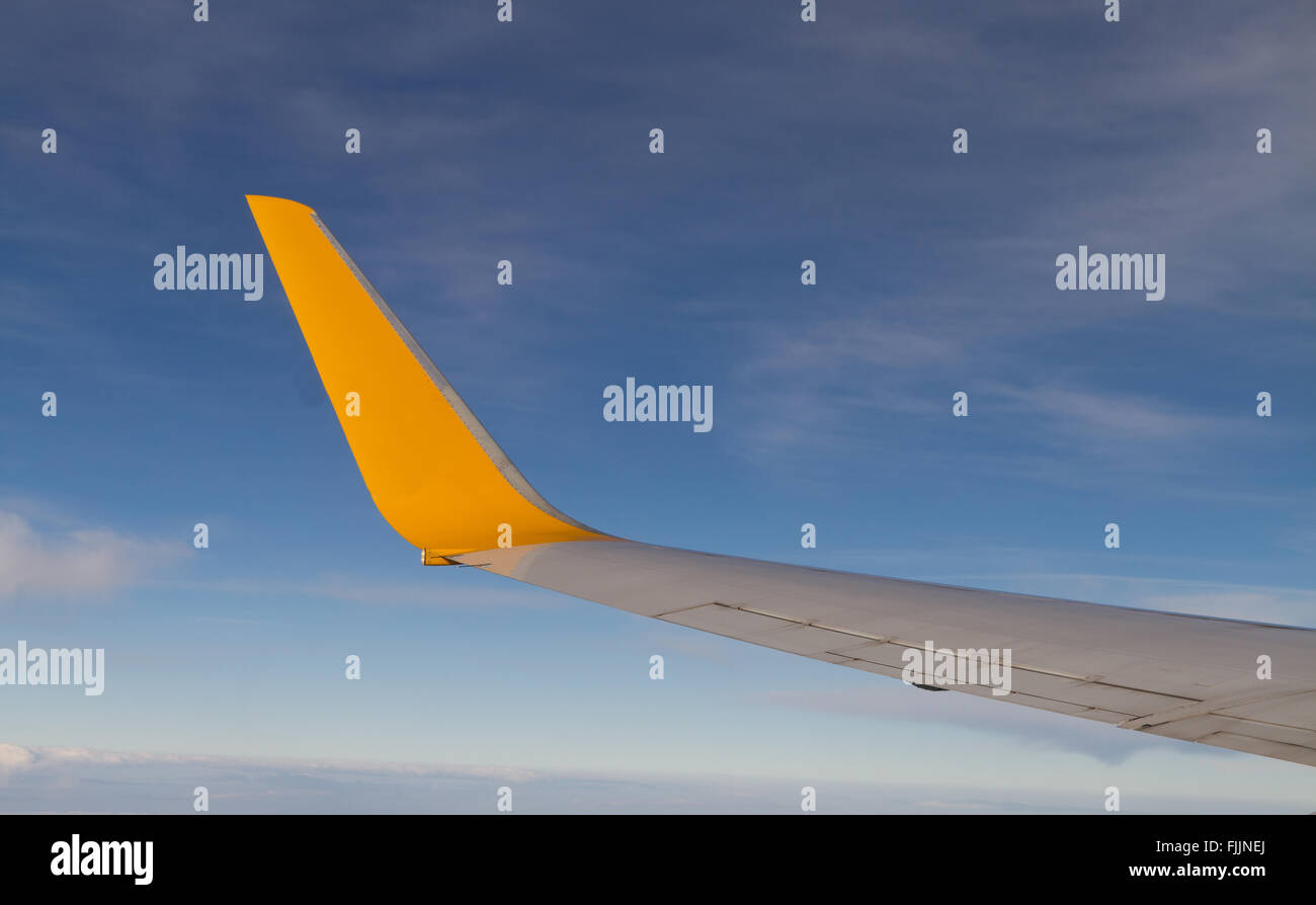 Yellow Airplane Wing and Wingtrip on sky Stock Photo - Alamy