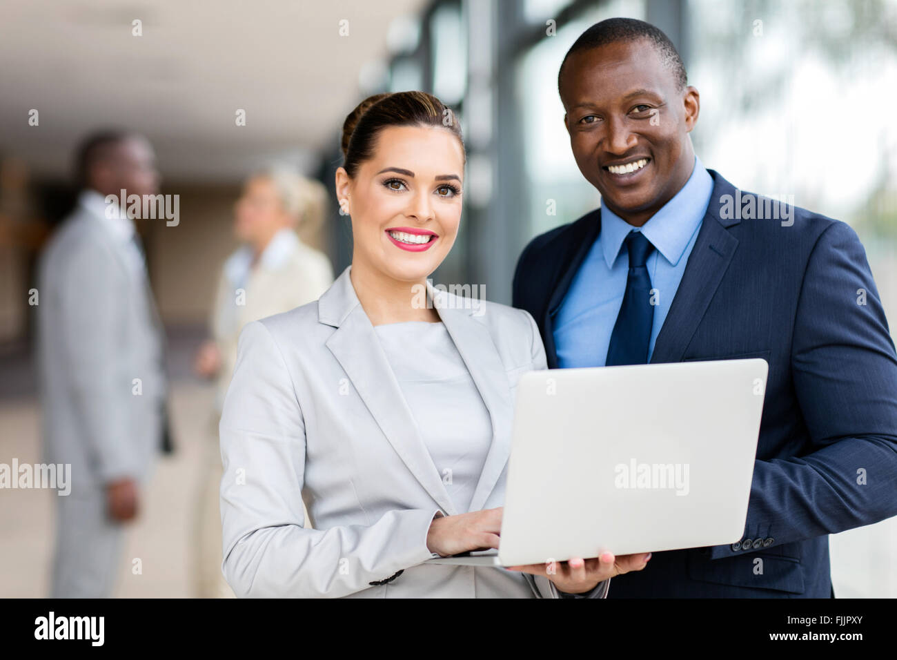 portrait of young colleagues using laptop computer Stock Photo - Alamy