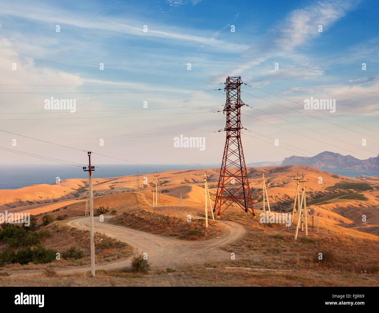 High voltage tower in mountains on the background of colorful sky at ...