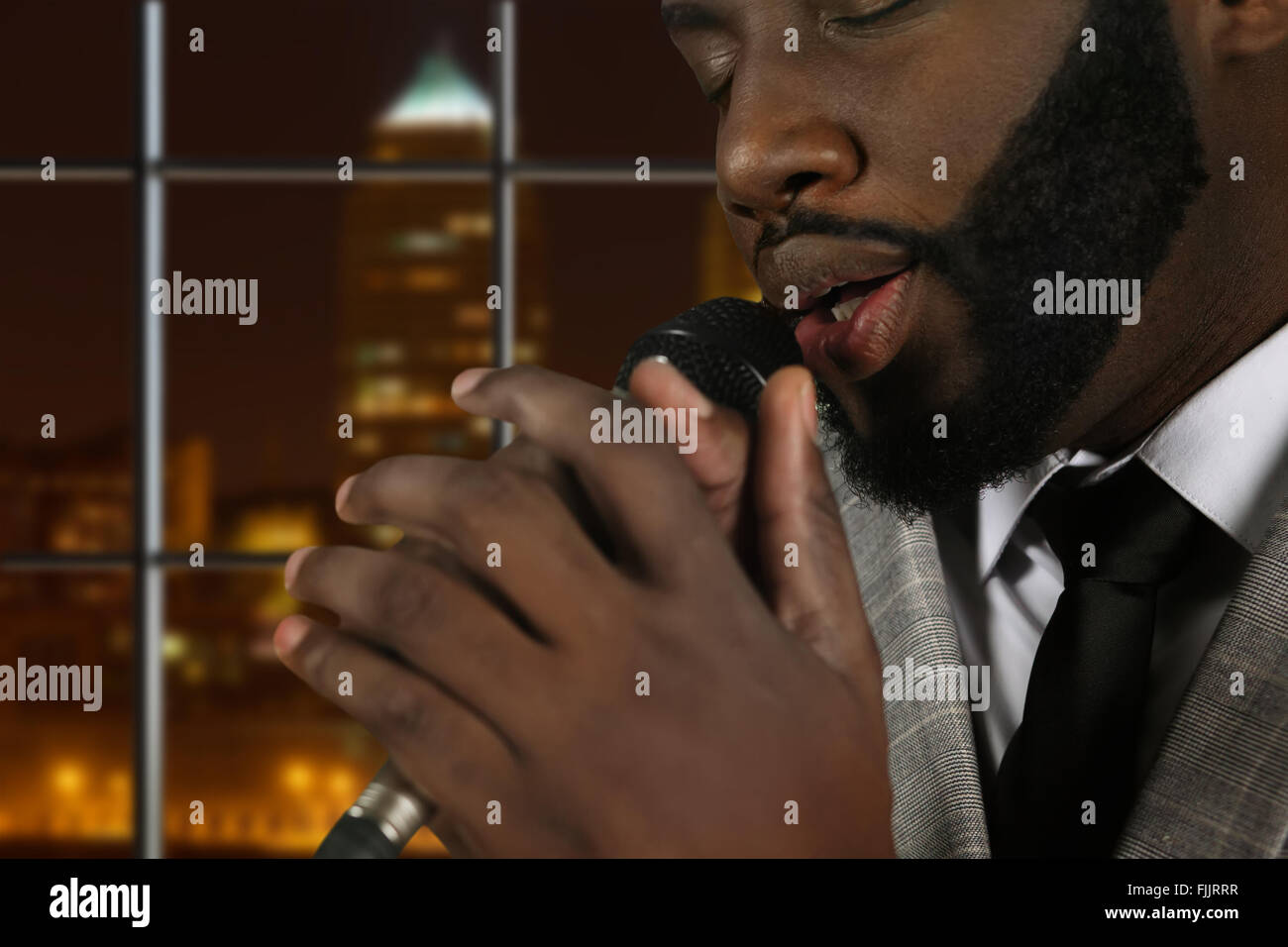 Elegant black man singing. Night jazz performance in studio ...